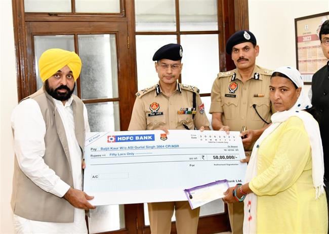 CM HANDS OVER CHEQUES WORTH RS 2 CRORE TO NEXT OF KIN OF COPS DIED ...